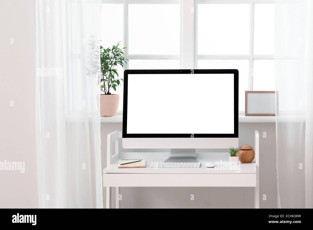 Modern PC monitor on table near window Stock Photo - Alamy