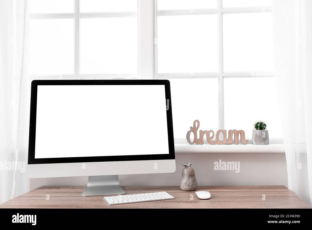 Modern PC monitor on table near window Stock Photo - Alamy