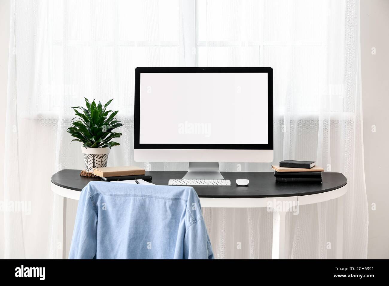 Modern PC monitor on table near window Stock Photo - Alamy