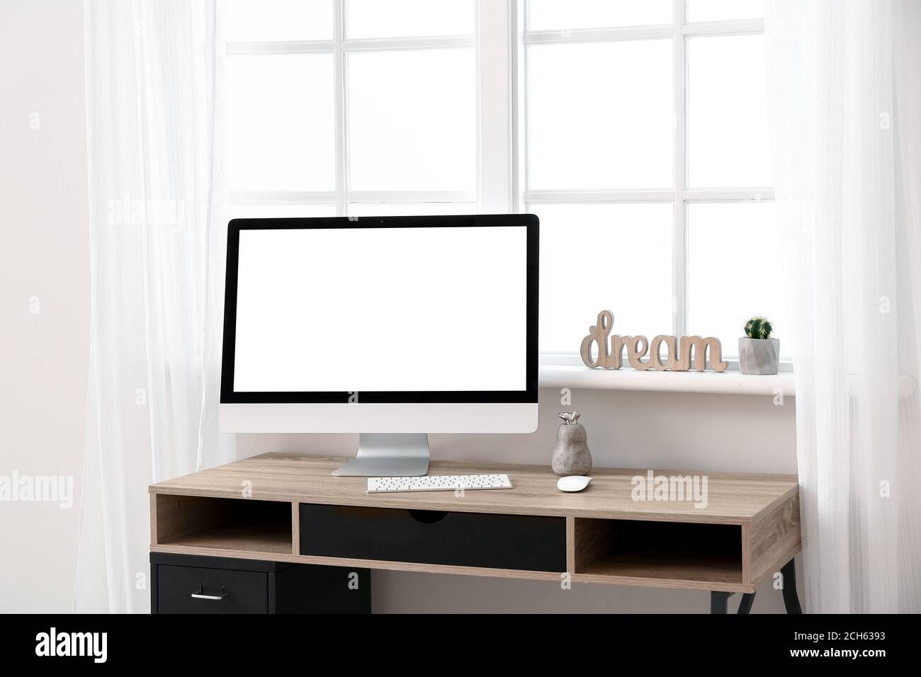 Modern PC monitor on table near window Stock Photo - Alamy