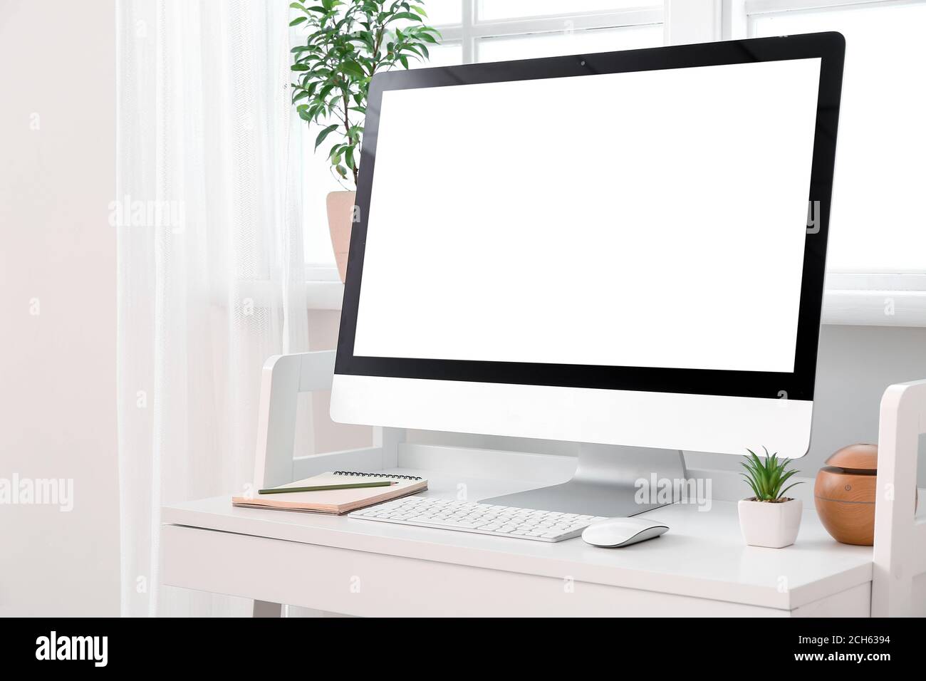 Modern PC monitor on table near window Stock Photo - Alamy