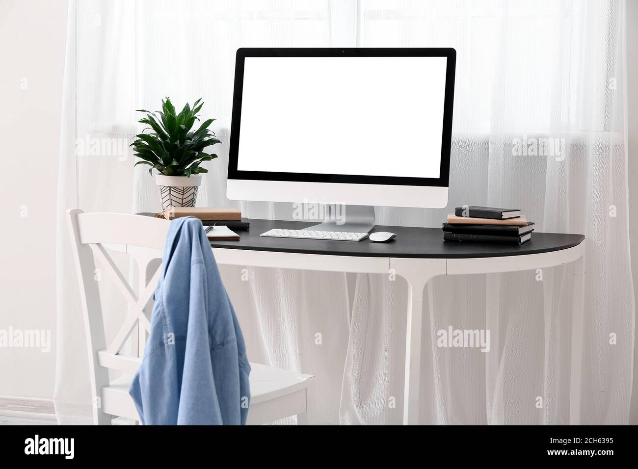 Modern PC monitor on table near window Stock Photo - Alamy