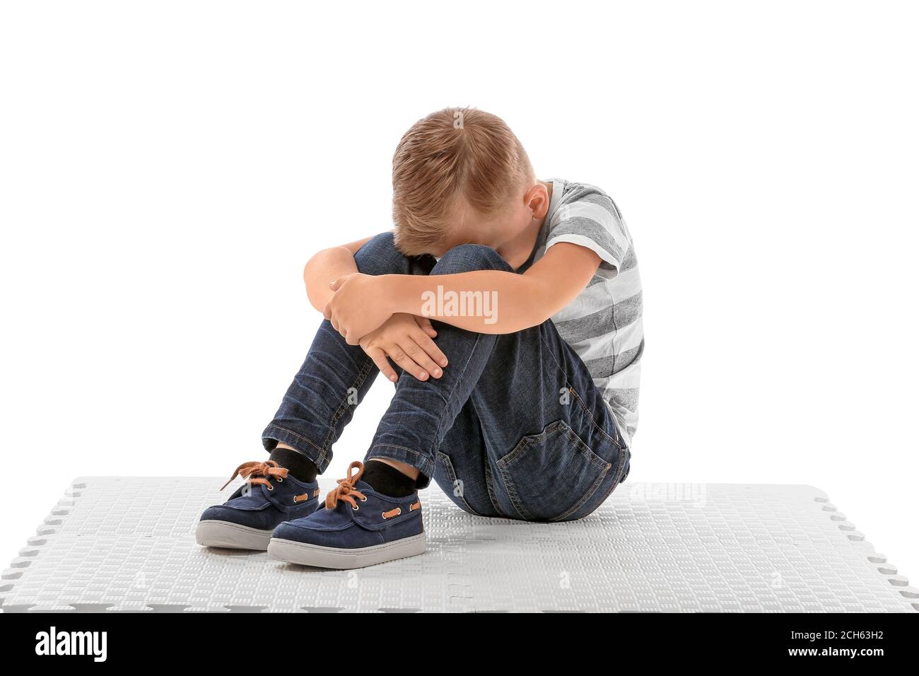 Sad little boy with autistic disorder on white background Stock Photo ...