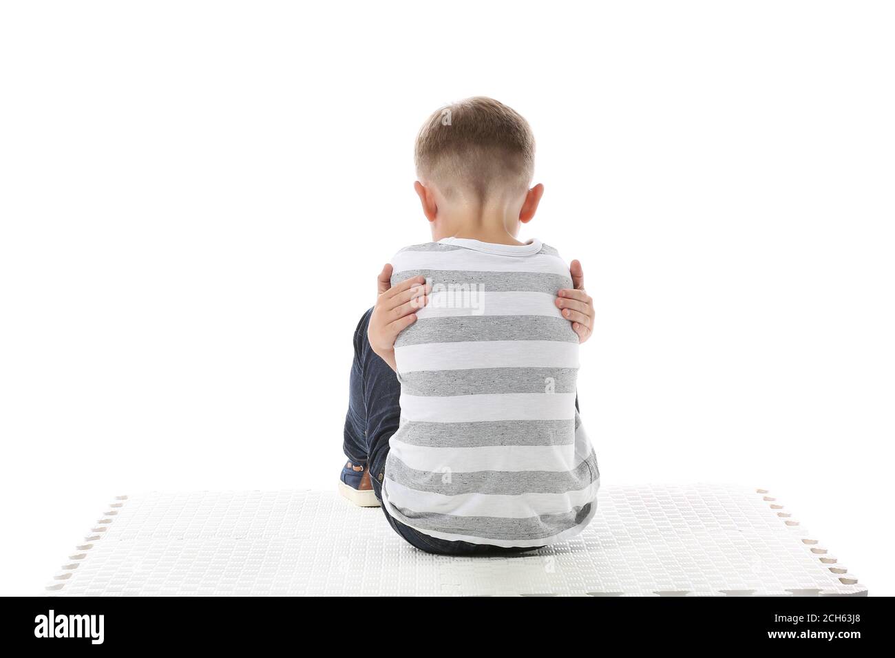 Sad little boy with autistic disorder on white background, back view ...