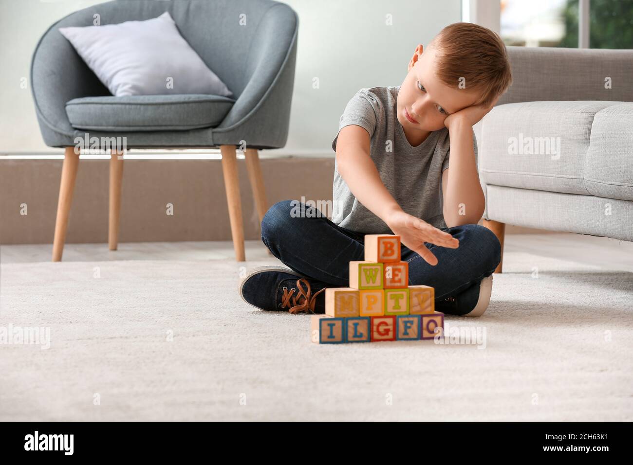 Little boy with autistic disorder playing with cubes at home Stock ...
