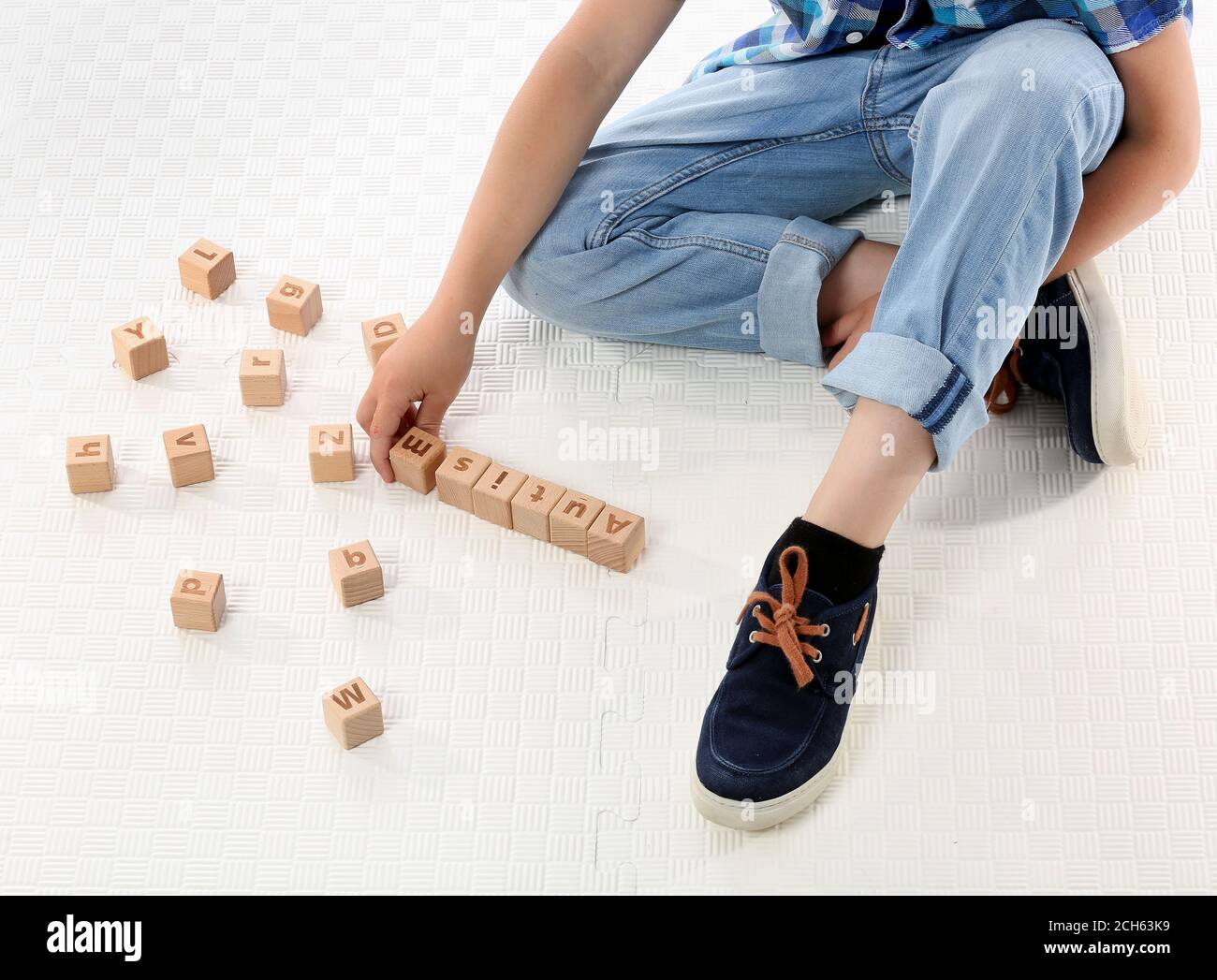 Little boy with autistic disorder playing with cubes on white ...