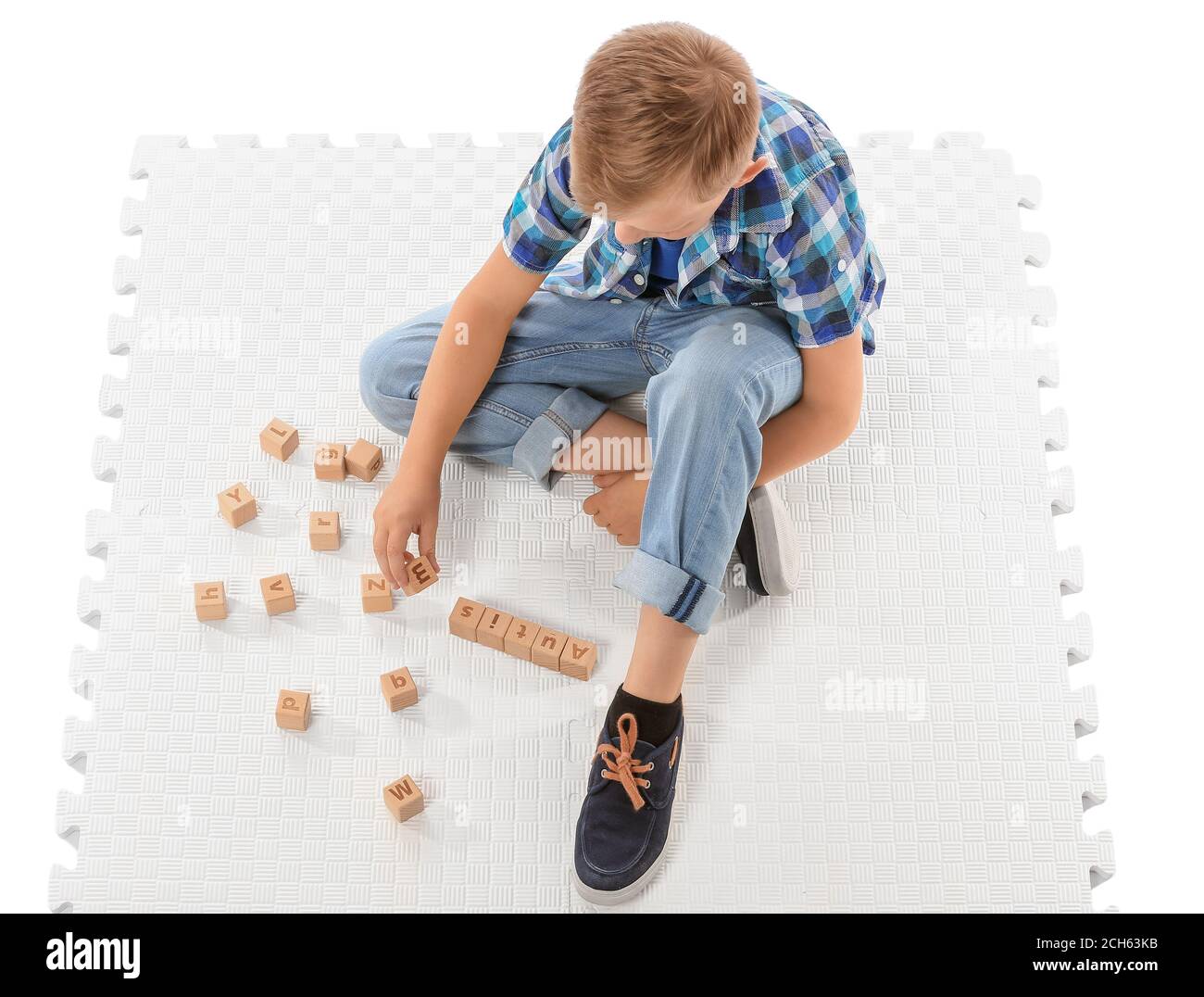 Little boy with autistic disorder playing with cubes on white ...