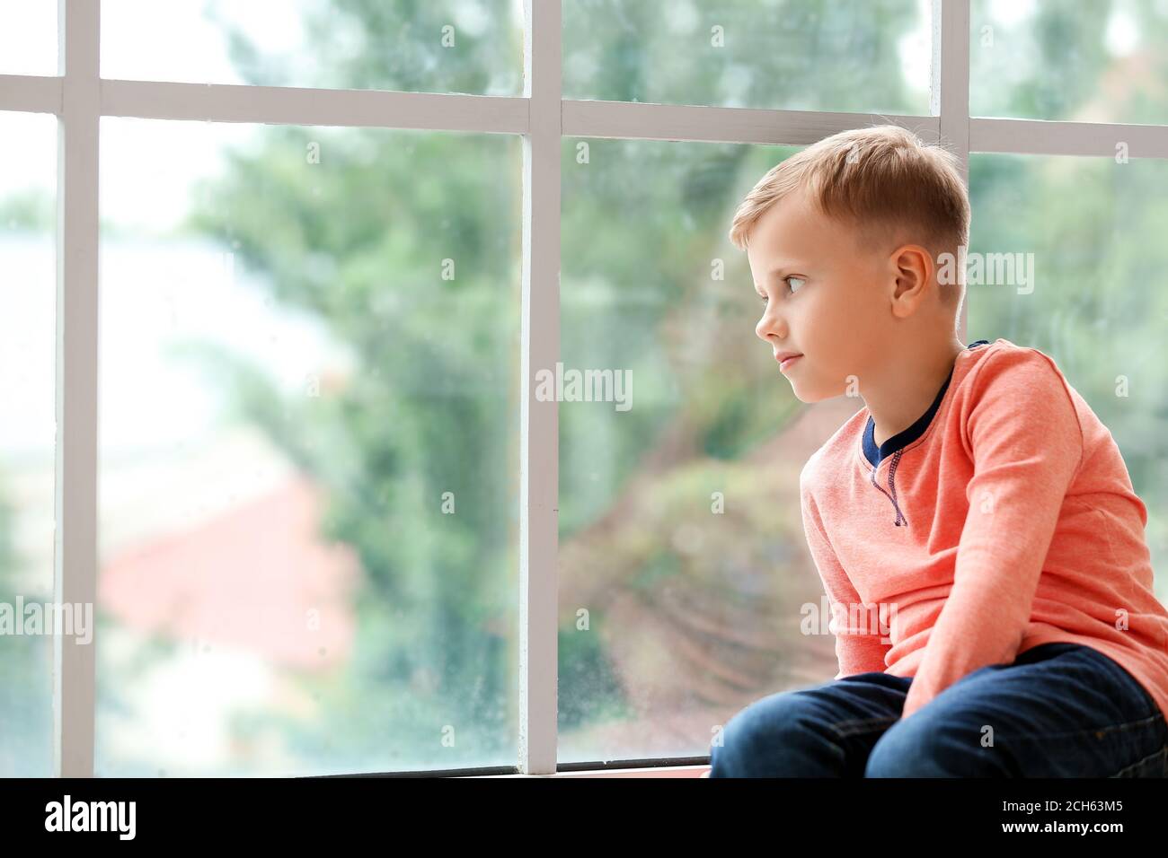 Little boy with autistic disorder sitting near window at home Stock ...
