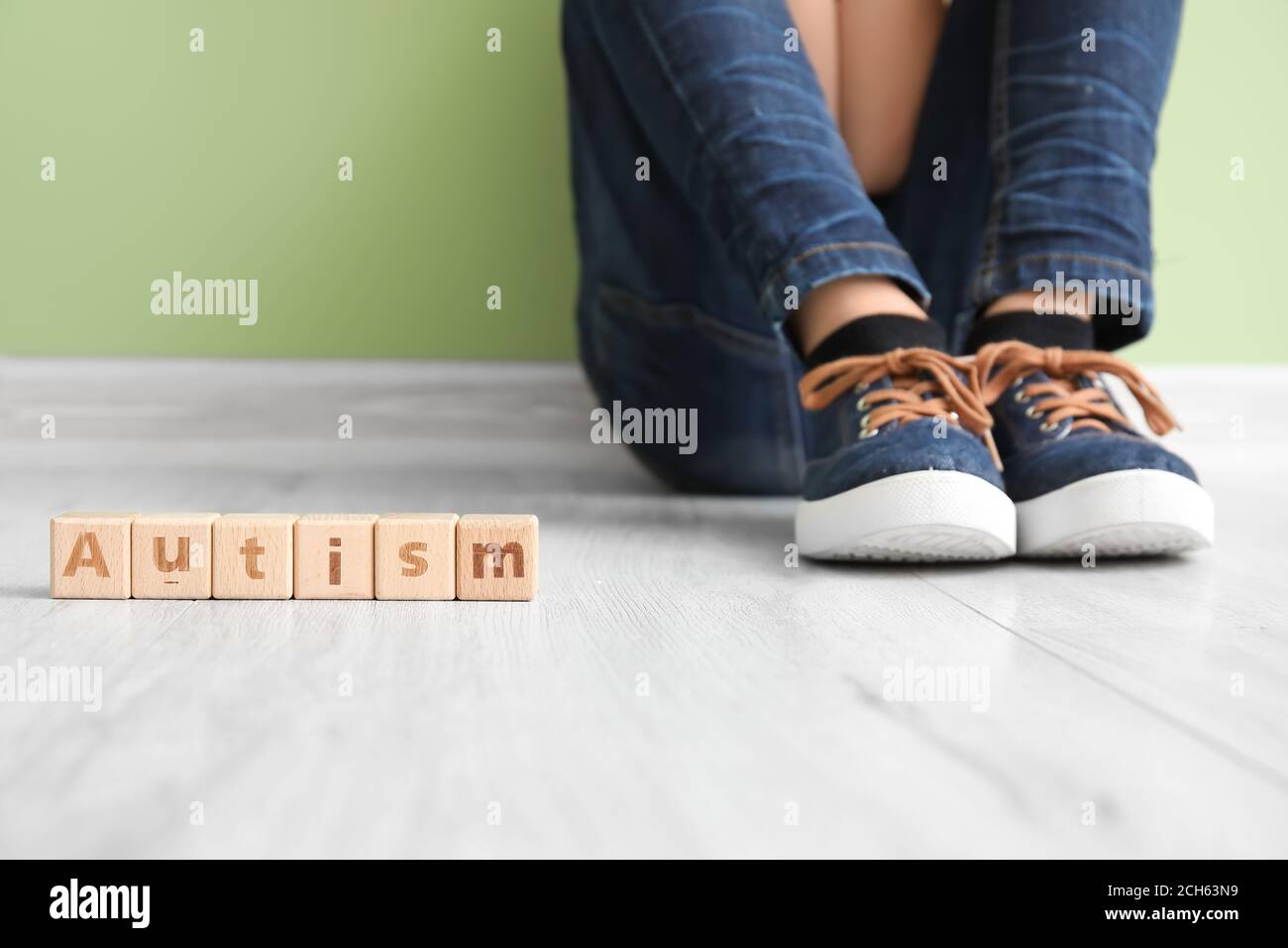 Little boy with autistic disorder sitting near color wall Stock Photo ...