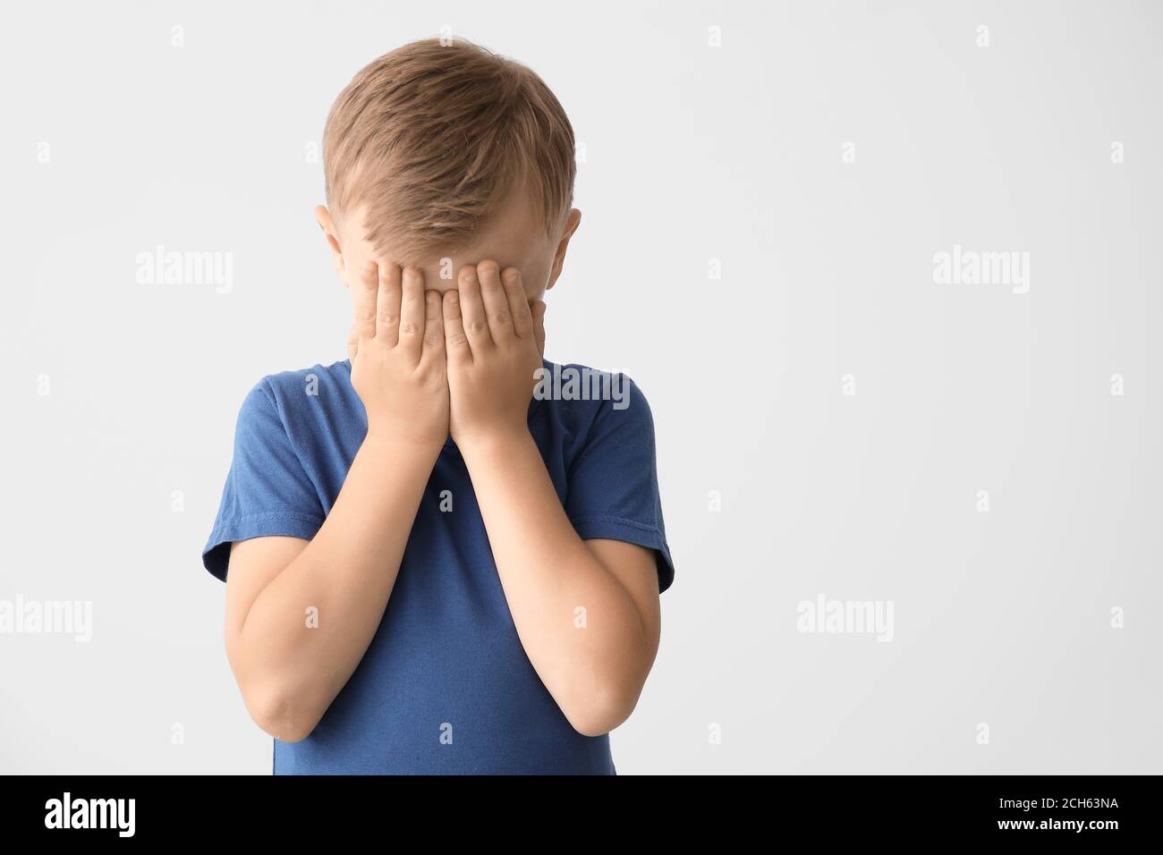 Sad little boy with autistic disorder on light background Stock Photo ...