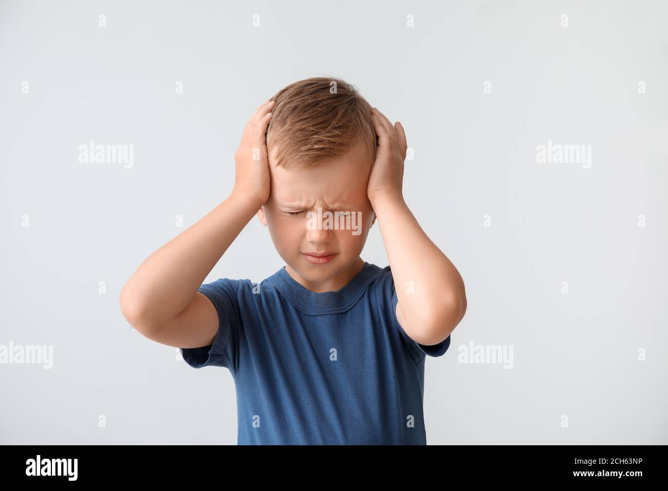 Sad little boy with autistic disorder on light background Stock Photo ...