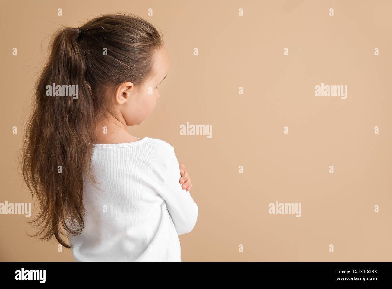 Little girl with autistic disorder on color background, back view Stock ...