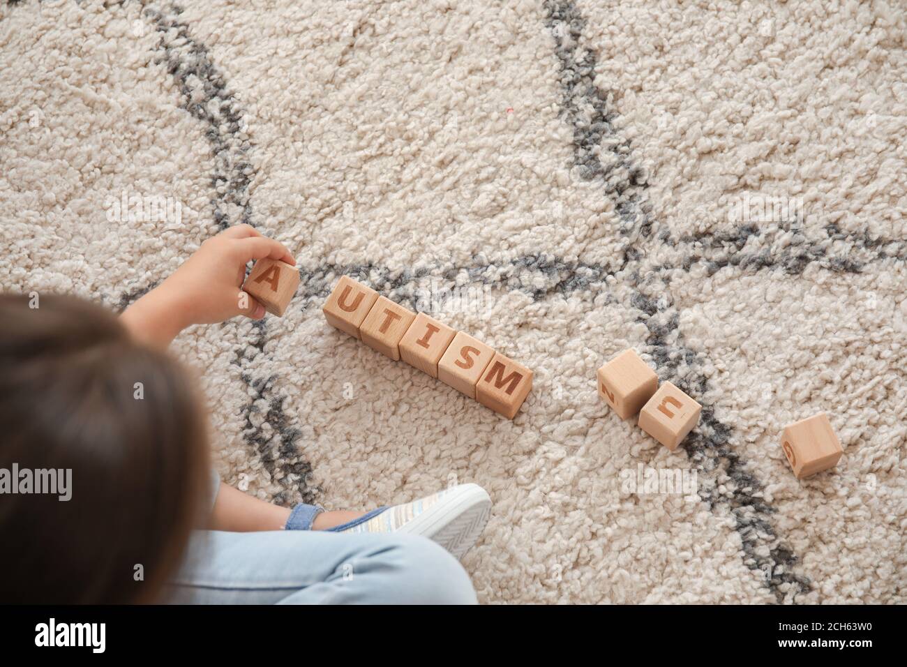 Little girl with autistic disorder playing with cubes at home Stock ...
