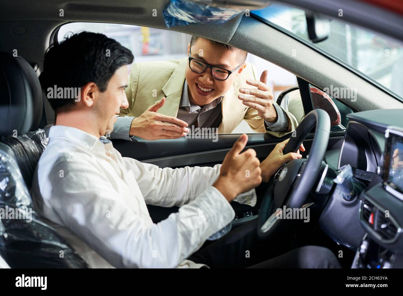 Young man examining new car Stock Photo - Alamy
