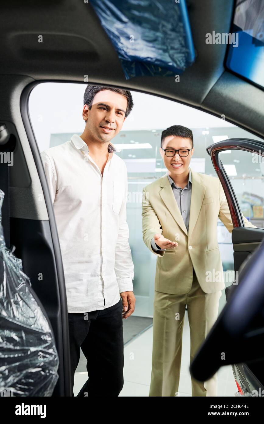 Salesman with customer in car salon Stock Photo - Alamy