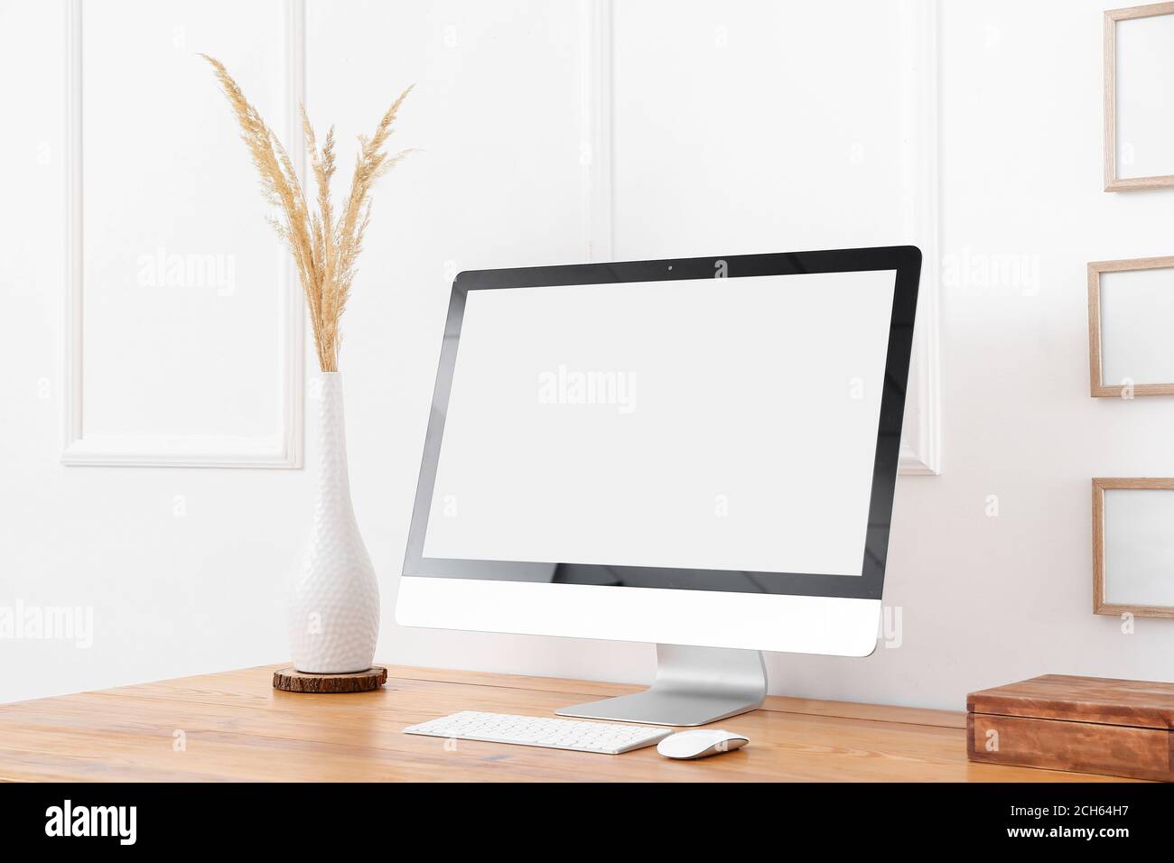 Modern PC monitor on table near light wall Stock Photo - Alamy