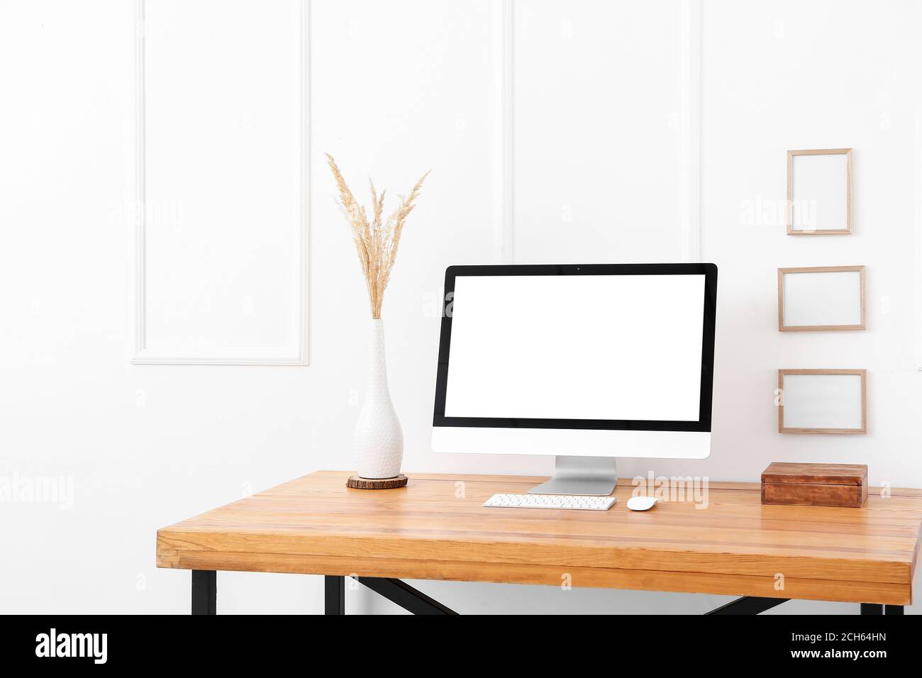 Modern PC monitor on table near light wall Stock Photo - Alamy
