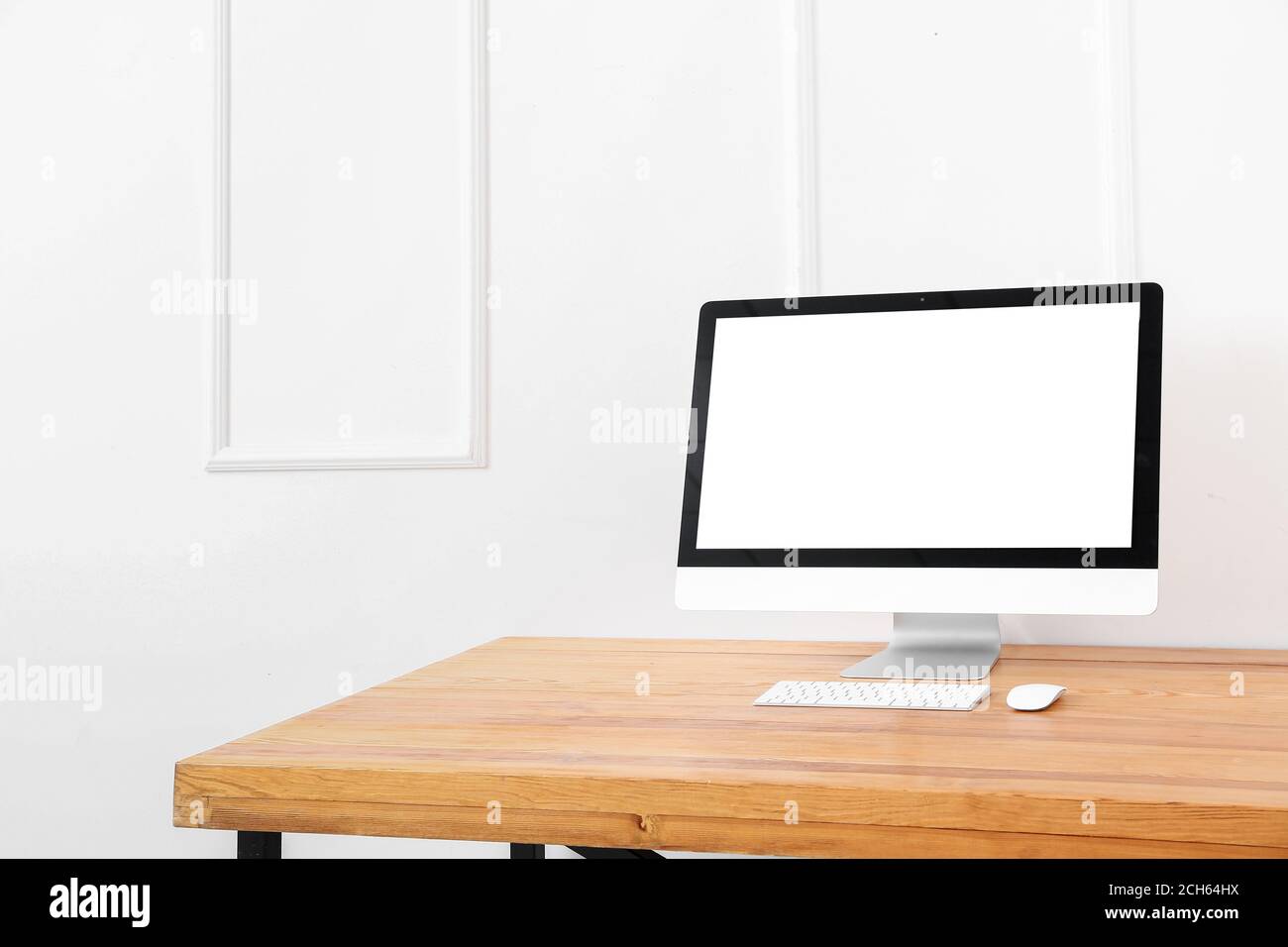 Modern PC monitor on table near light wall Stock Photo - Alamy