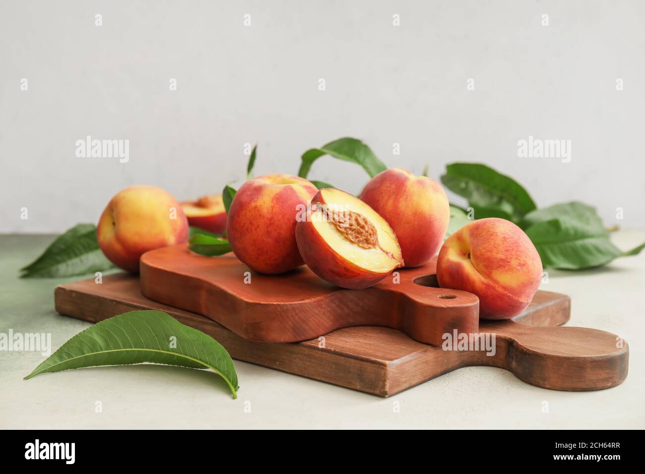 Boards with ripe peaches on light background Stock Photo - Alamy