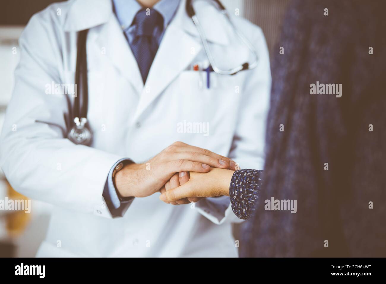Friendly red-beard doctor reassuring his female patient, close-up ...