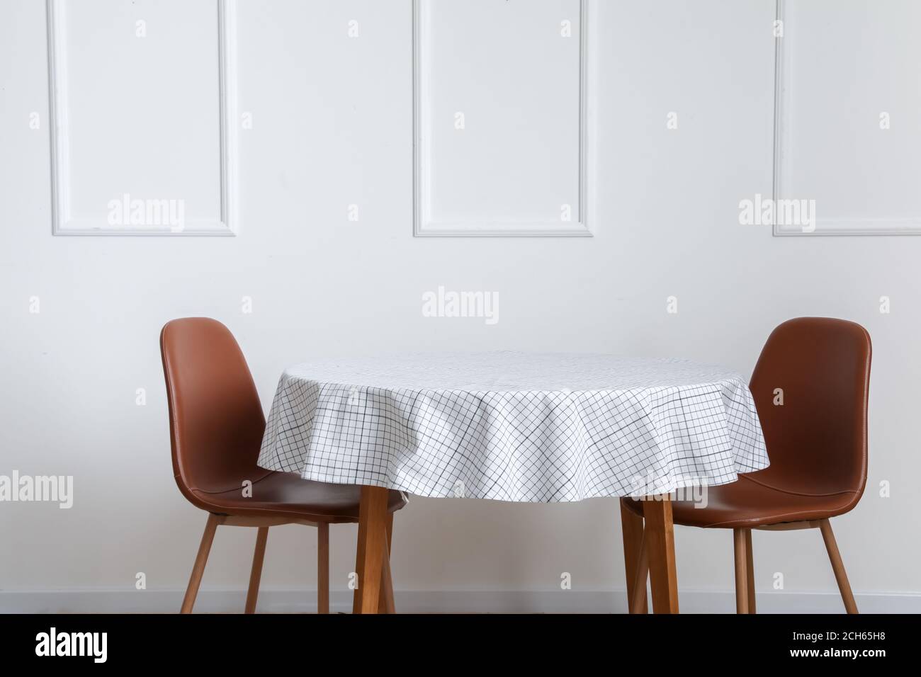 Dining table near white wall Stock Photo - Alamy