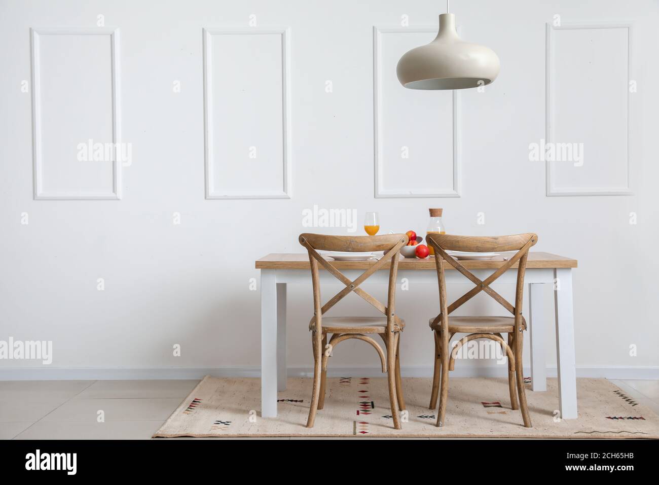 Dining table near white wall Stock Photo - Alamy