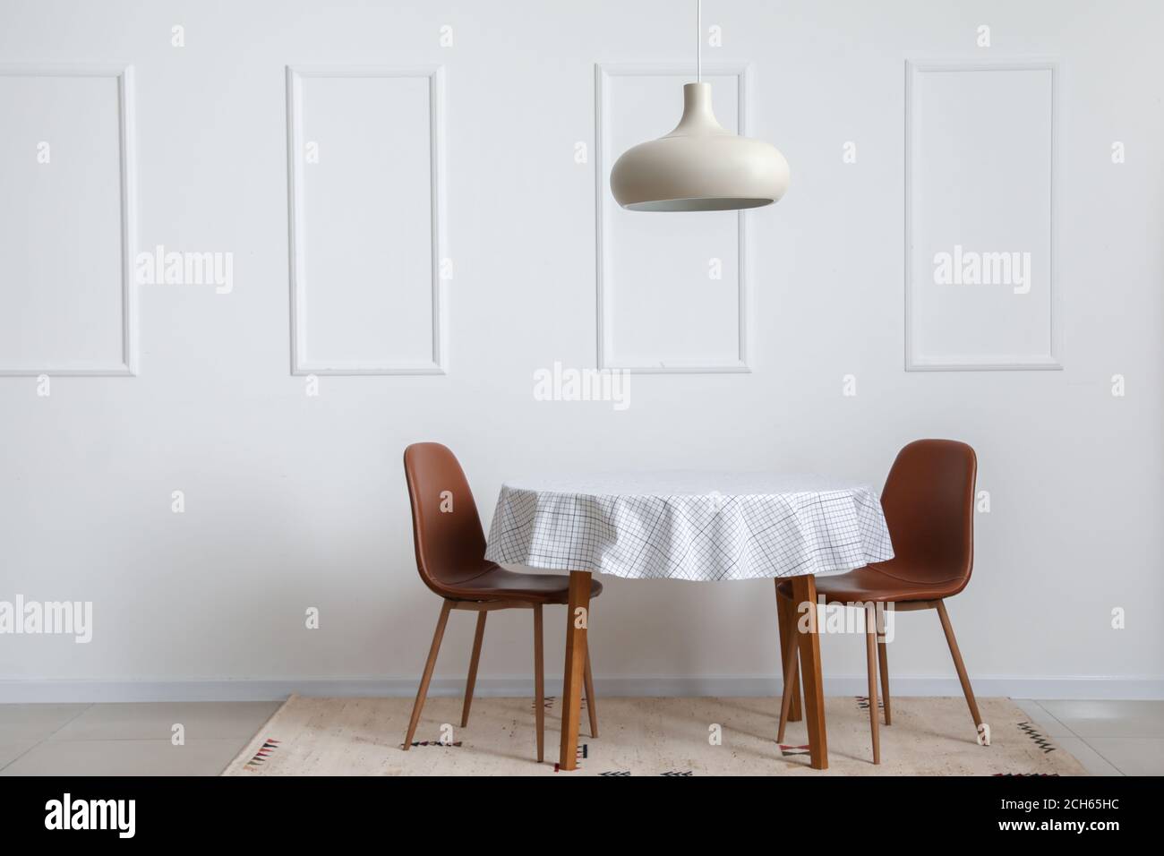Dining table near white wall Stock Photo - Alamy