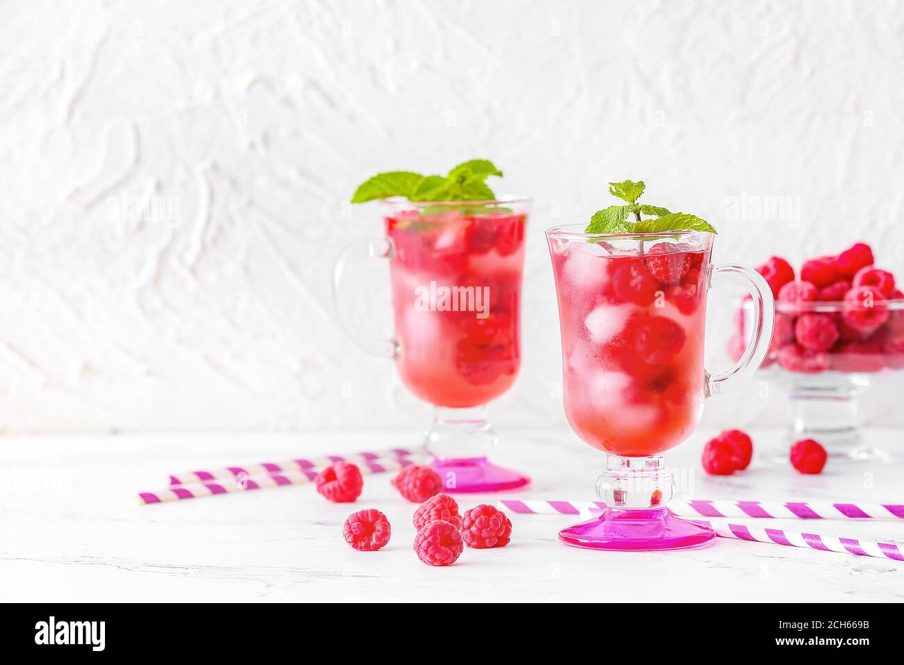 Cups of cold raspberry tea on white background Stock Photo - Alamy