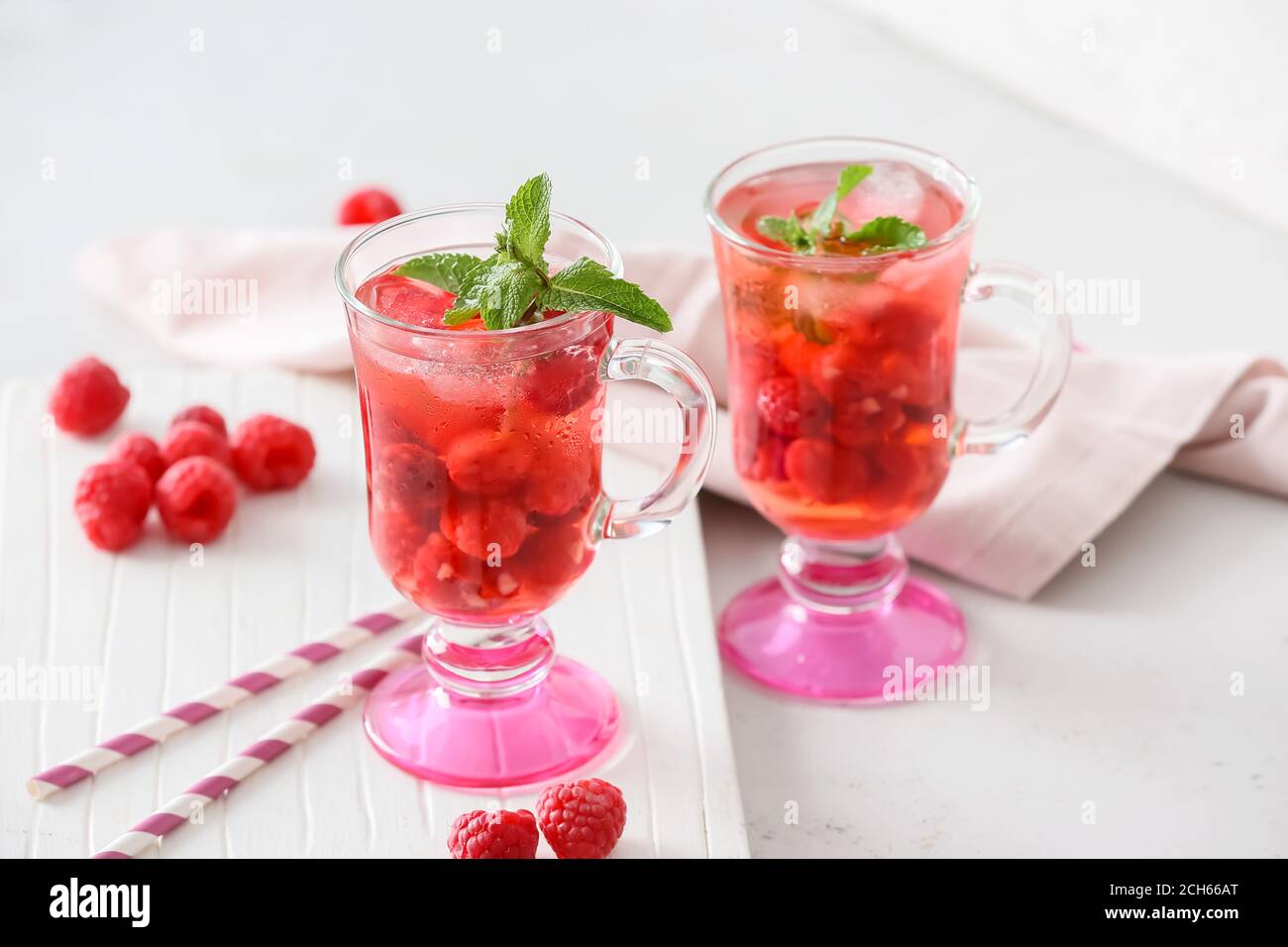 Cups of cold raspberry tea on white background Stock Photo - Alamy