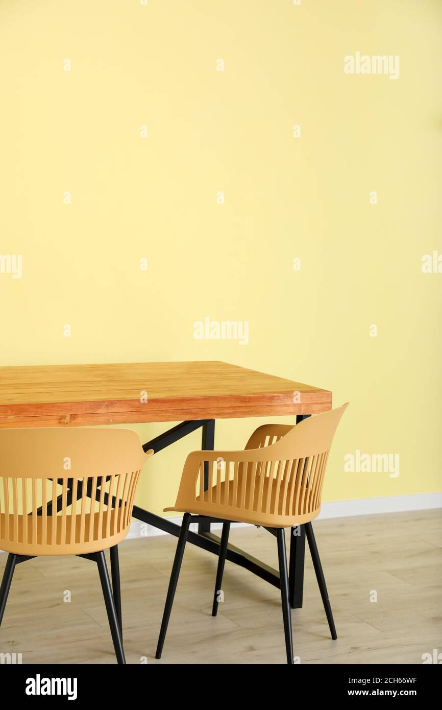 Dining table near color wall Stock Photo - Alamy