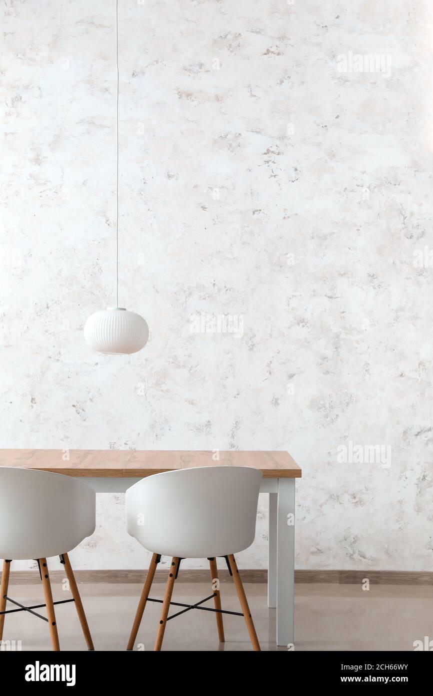 Dining table near light wall Stock Photo - Alamy