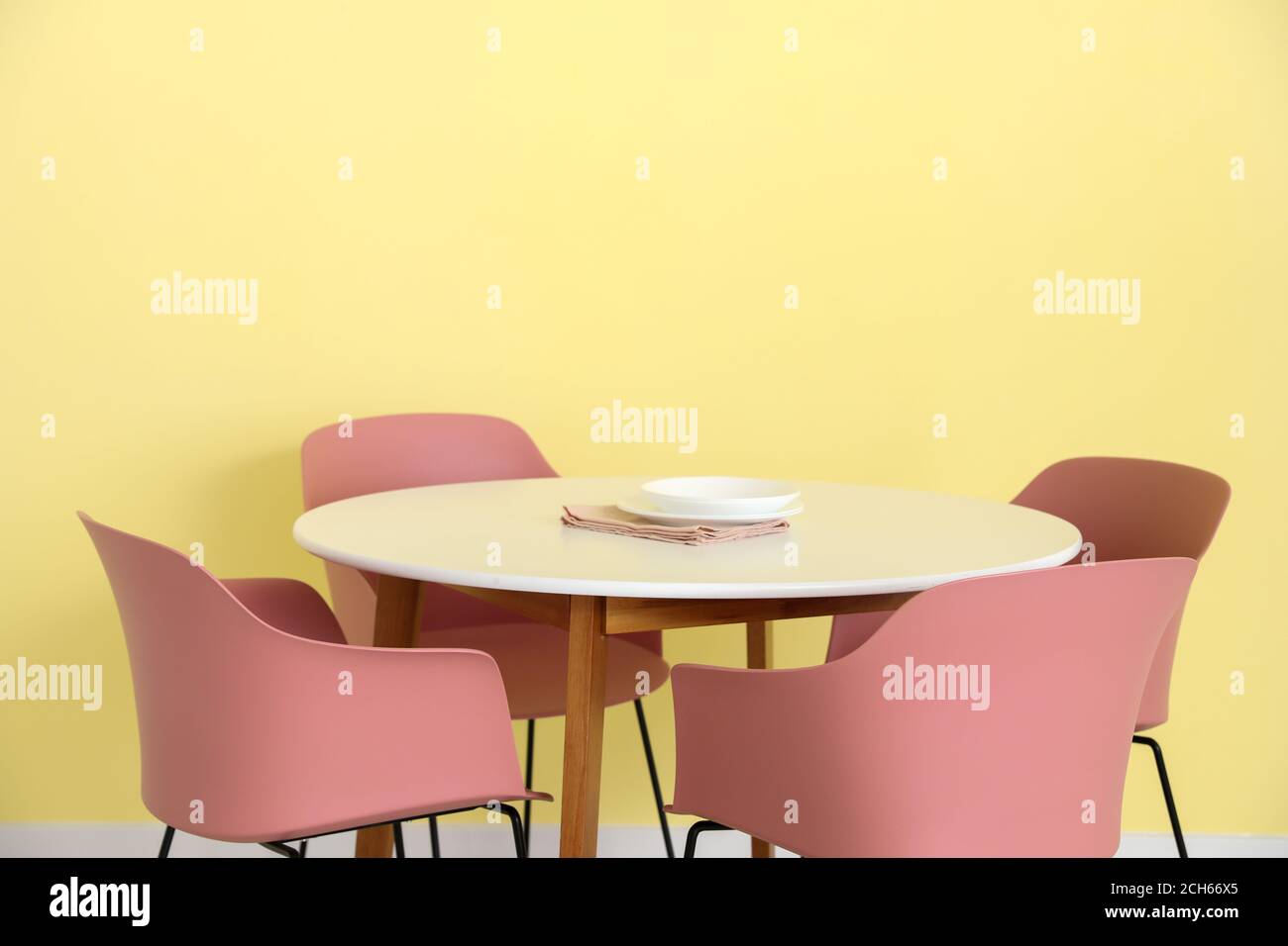 Dining table near color wall Stock Photo - Alamy