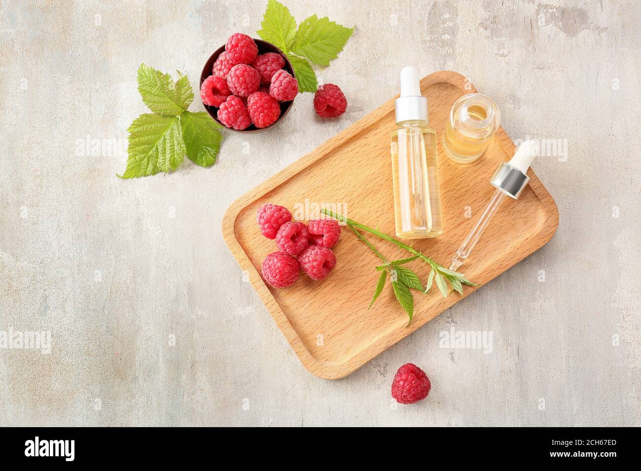 Bottles of raspberry essential oil on grey background Stock Photo - Alamy
