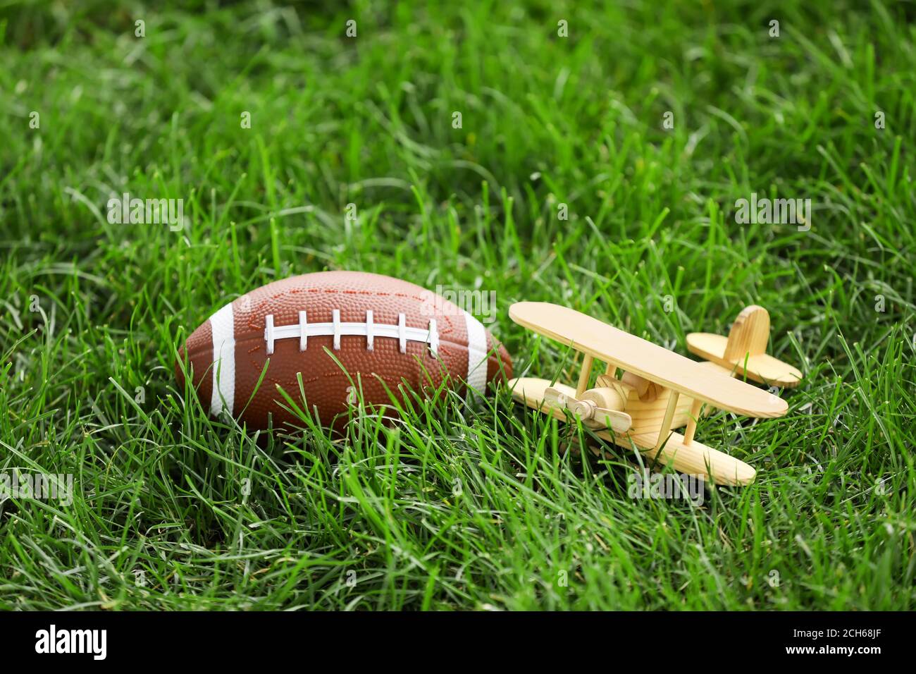 Rugby ball with wooden airplane outdoors Stock Photo - Alamy