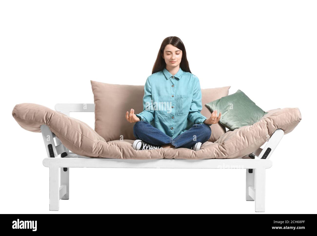 Young woman meditating on sofa against white background Stock Photo - Alamy