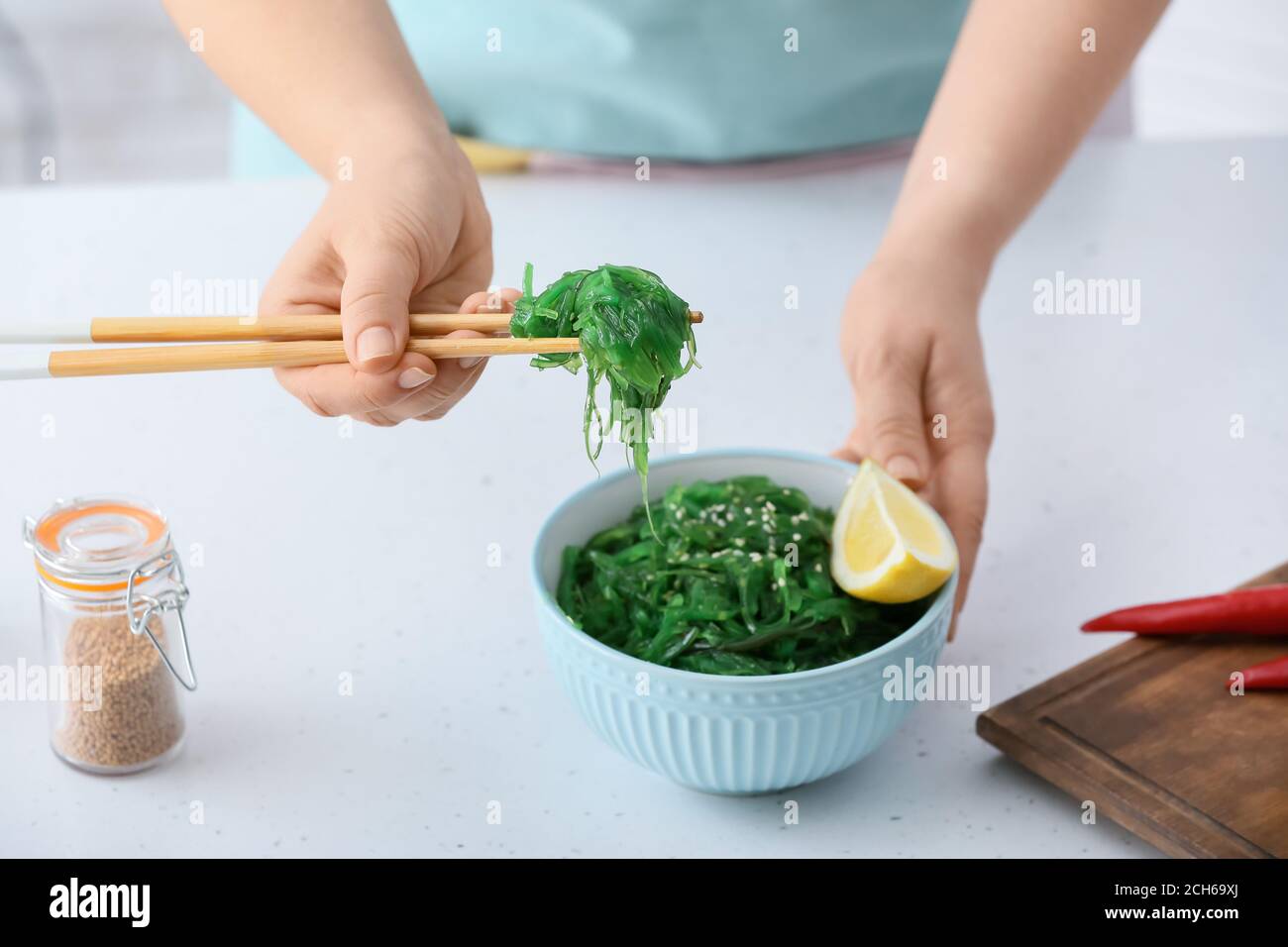 Woman eating tasty seaweed salad at table Stock Photo - Alamy