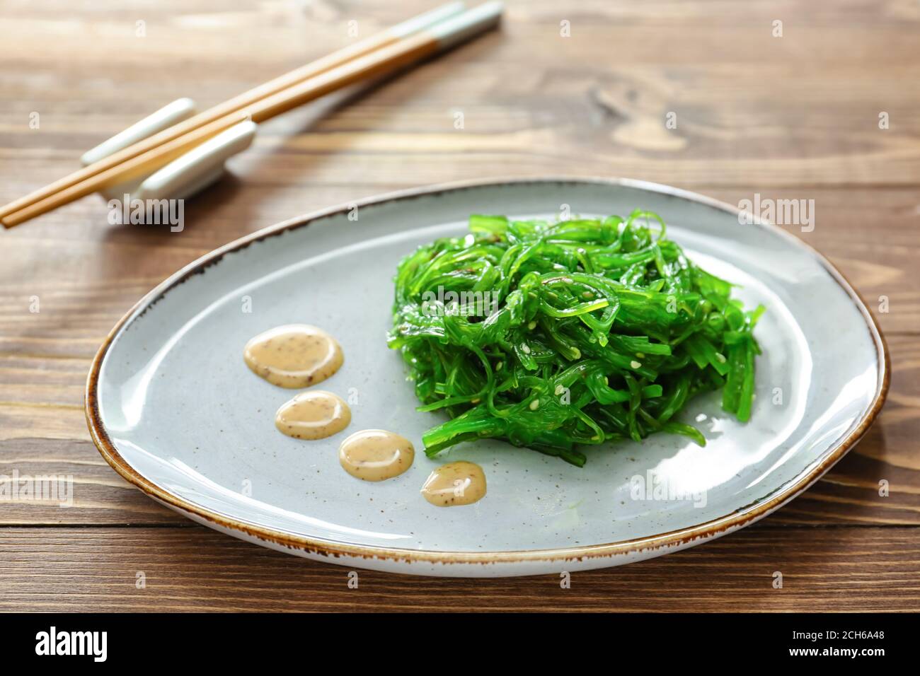 Plate with tasty seaweed salad on table Stock Photo - Alamy