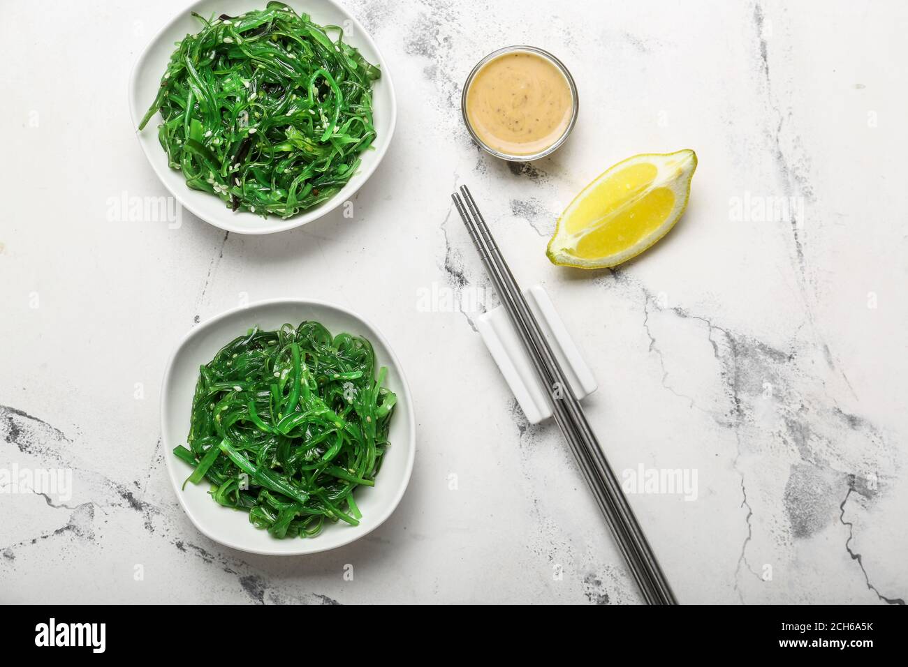 Plates with tasty seaweed salad on white background Stock Photo - Alamy