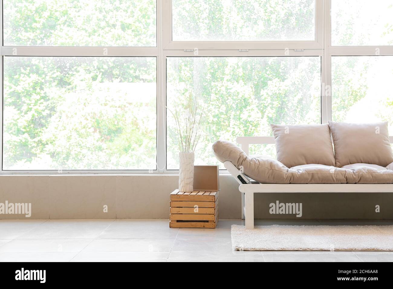 Stylish modern sofa near window in room Stock Photo - Alamy