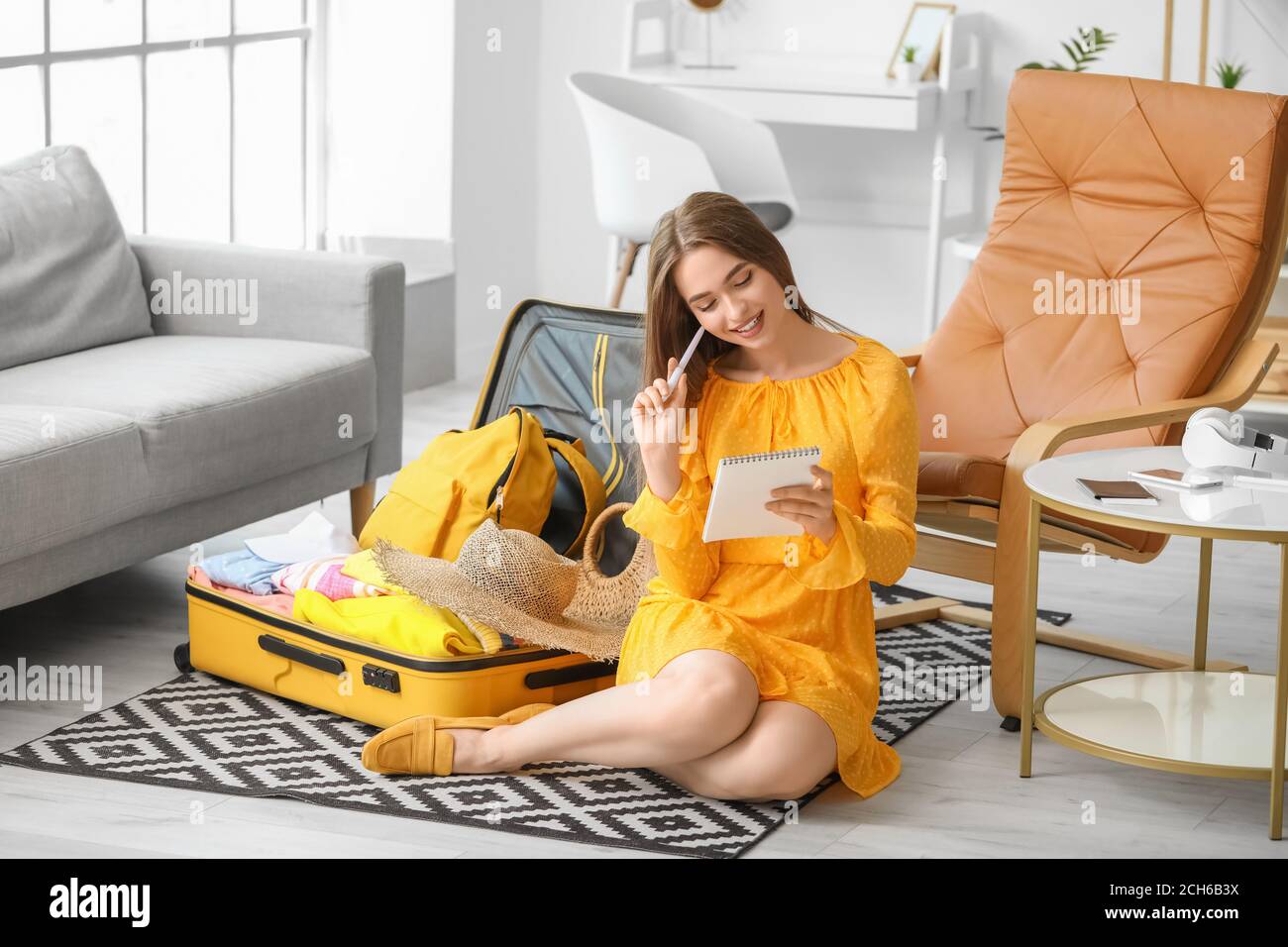 Young woman packing suitcase at home. Travel concept Stock Photo - Alamy