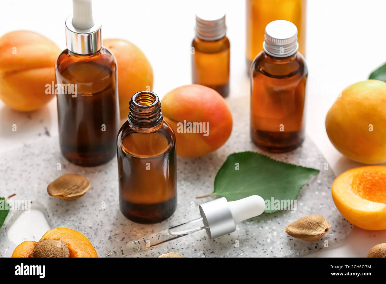 Bottles of apricot essential oil on white background Stock Photo - Alamy