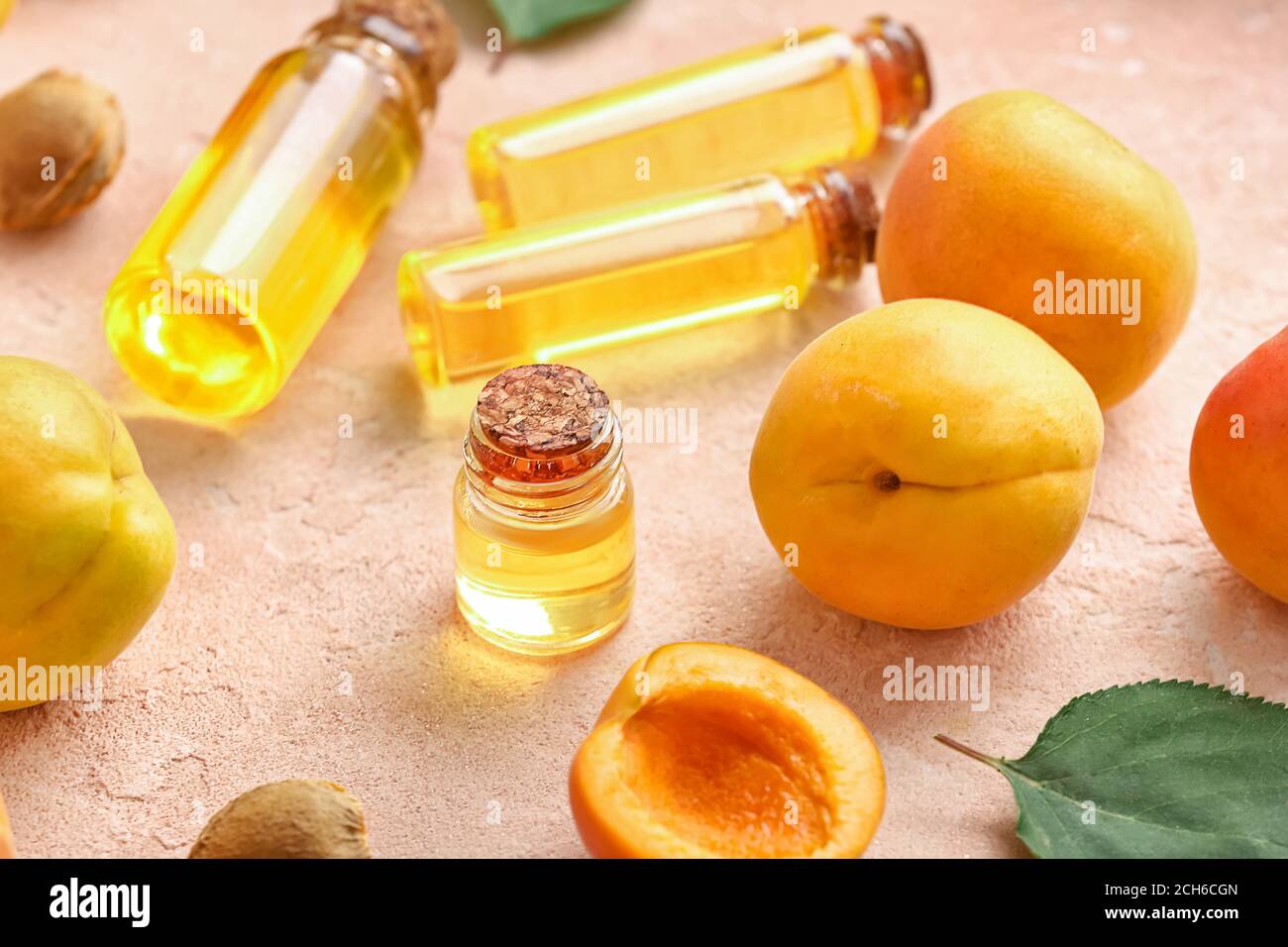 Bottles of apricot essential oil on color background Stock Photo - Alamy