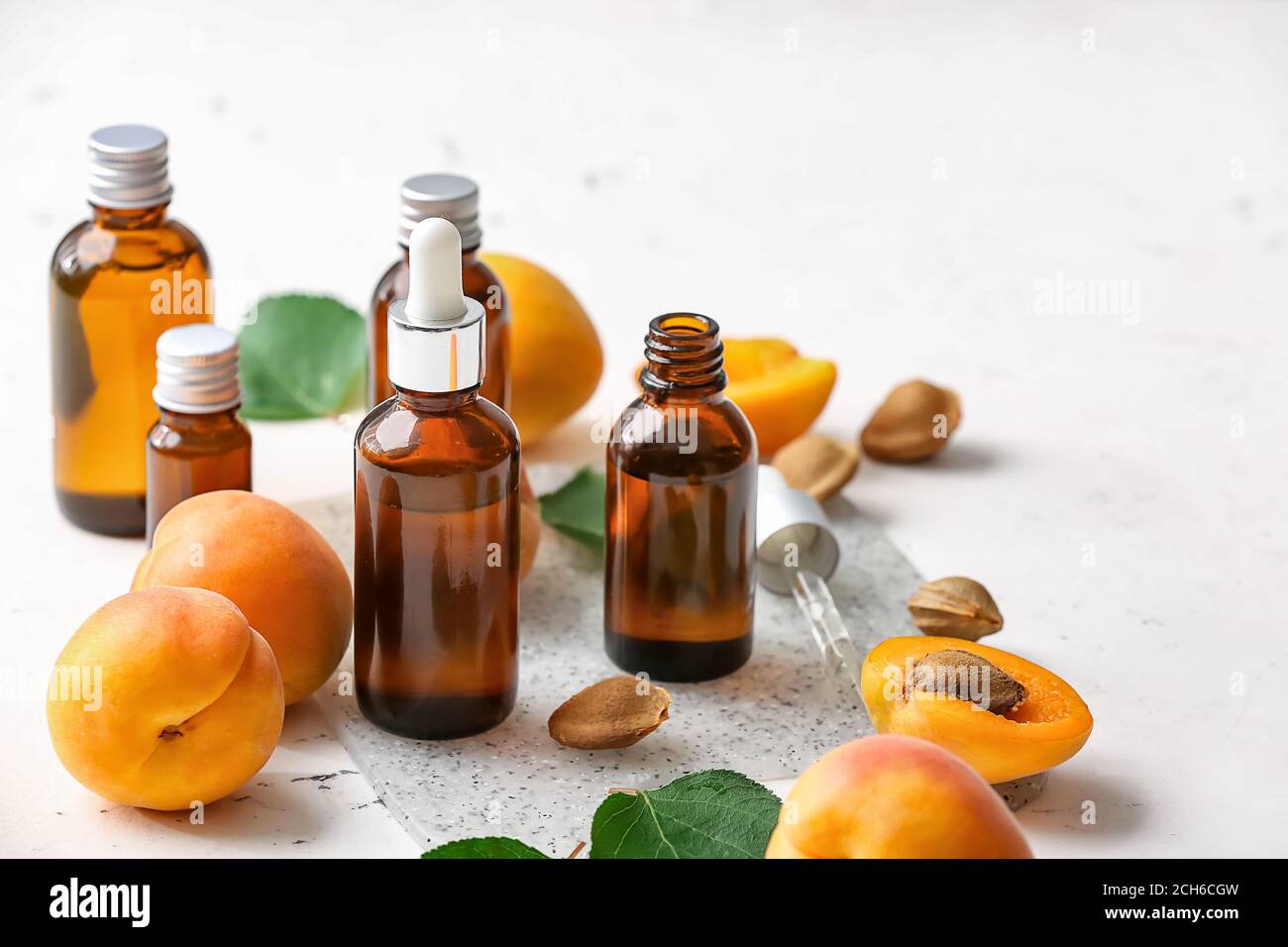 Bottles of apricot essential oil on white background Stock Photo - Alamy