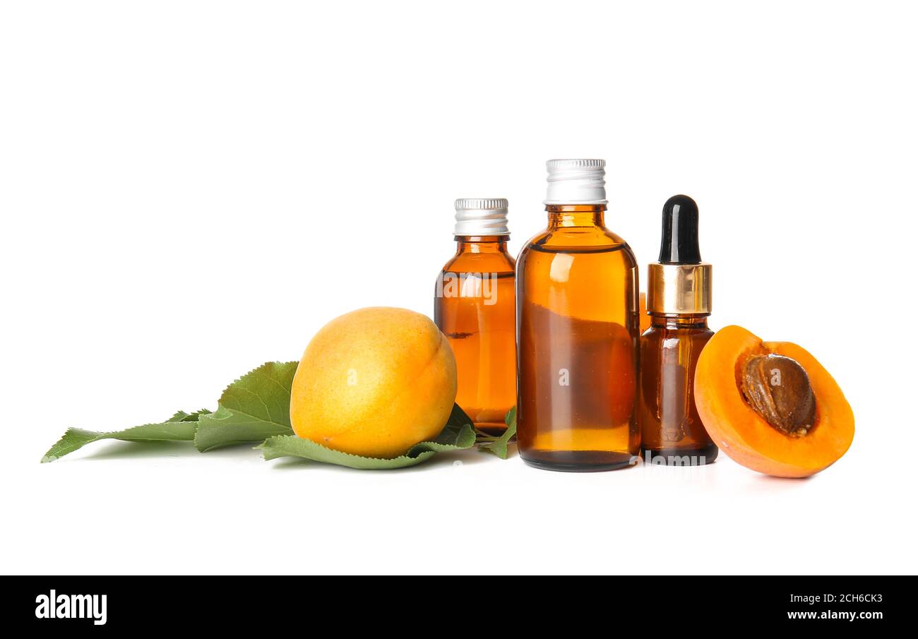 Bottles of apricot essential oil on white background Stock Photo - Alamy