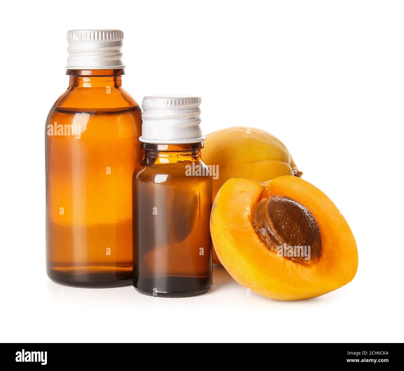 Bottles of apricot essential oil on white background Stock Photo - Alamy