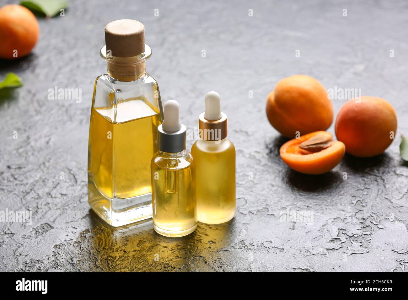 Bottles of apricot essential oil on dark background Stock Photo - Alamy
