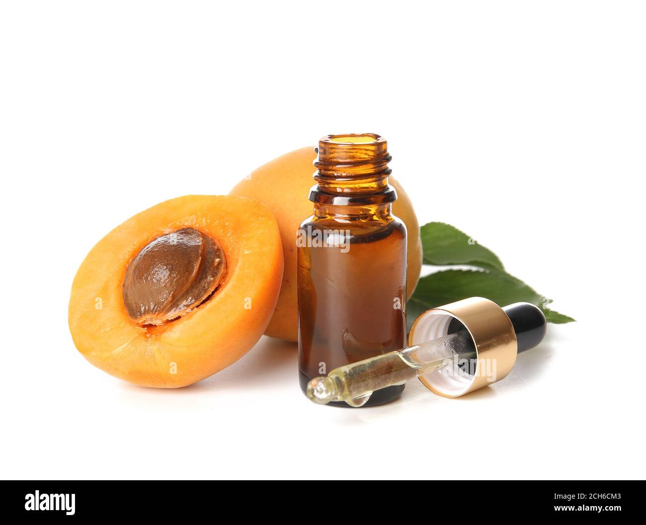 Bottle of apricot essential oil on white background Stock Photo - Alamy
