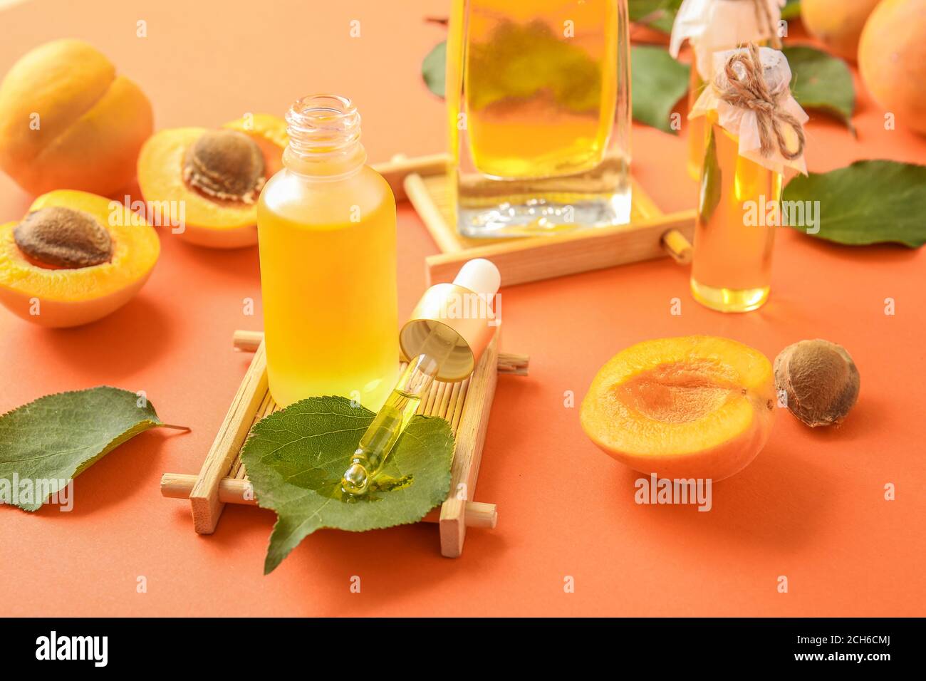 Bottles of apricot essential oil on color background Stock Photo - Alamy