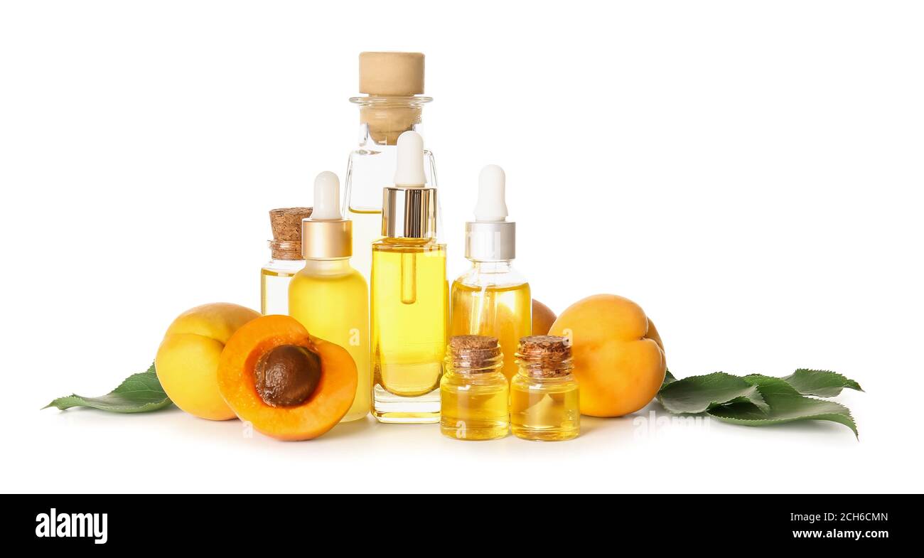 Bottles of apricot essential oil on white background Stock Photo - Alamy