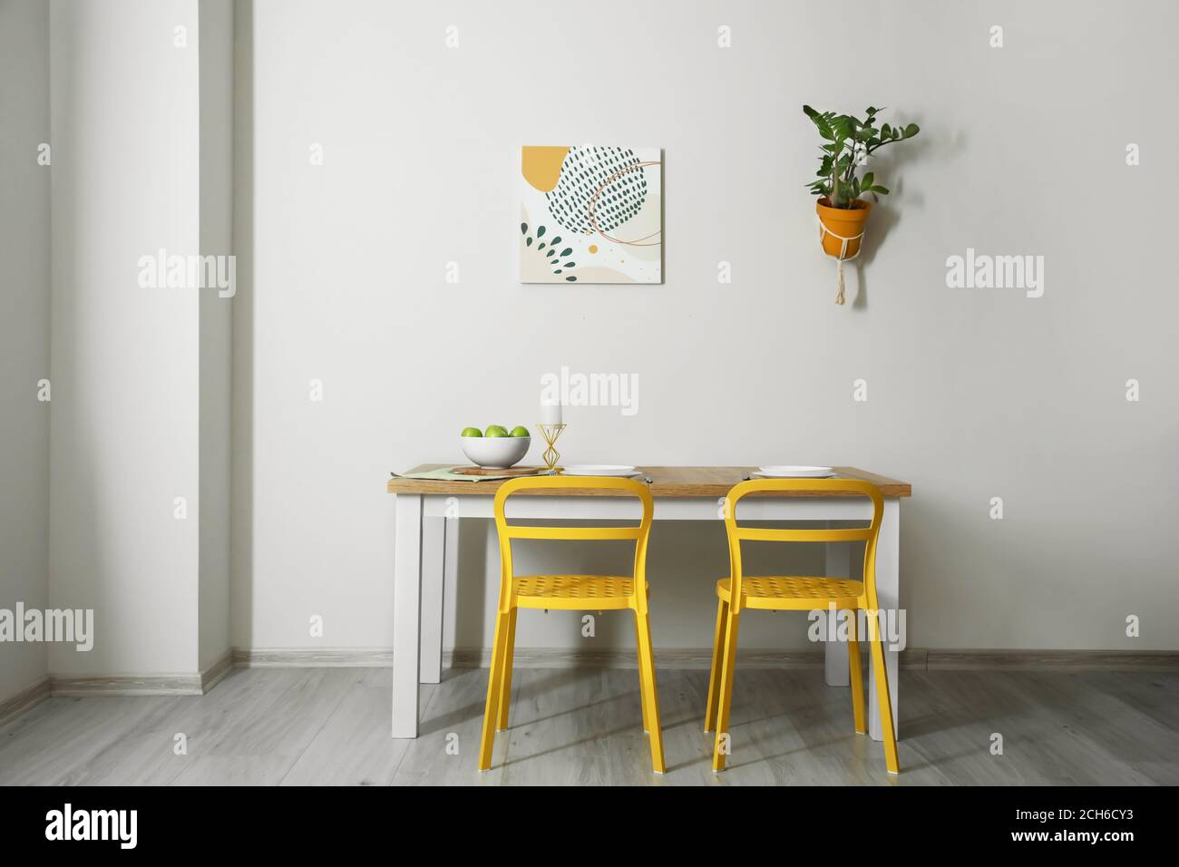 Table and chairs near light wall Stock Photo - Alamy